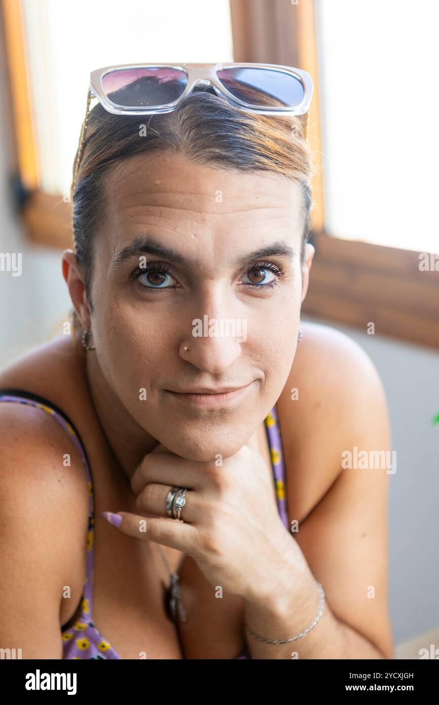 A close-up portrait featuring a trans woman smiling gently at the ...