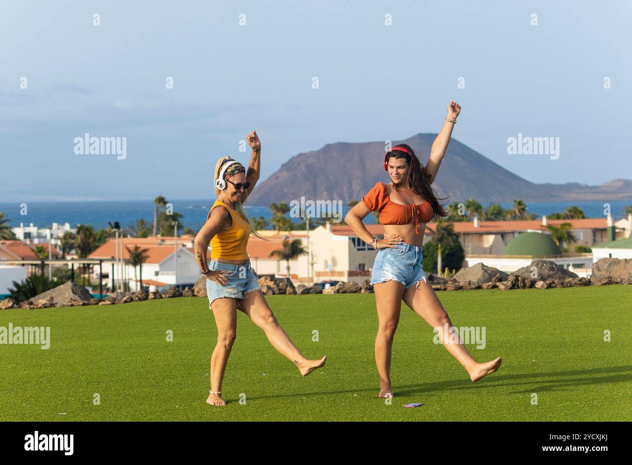 A mother and her transgender daughter joyfully dance together on a lush ...