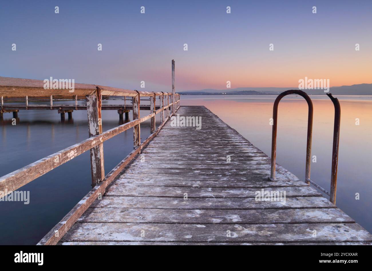 Old rustic timber plan jetty and whitewashed by nature in the light of ...