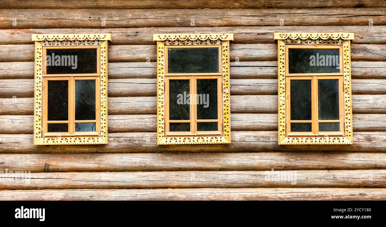 Windows of old log house with carved wooden trim Stock Photo - Alamy