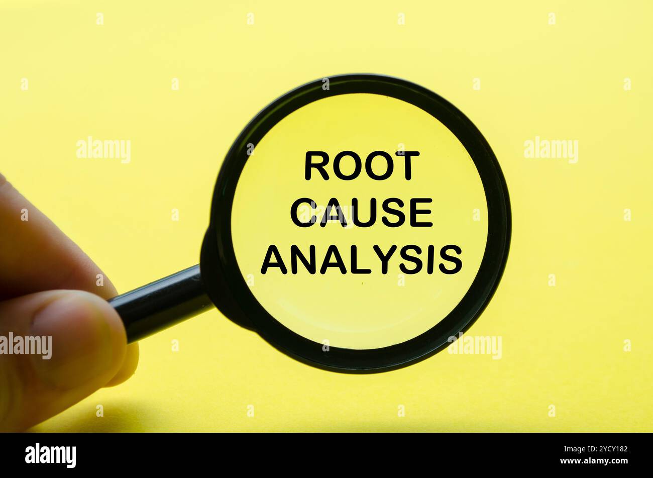 Hand holding magnifying with Root Cause Analysis text on yellow ...