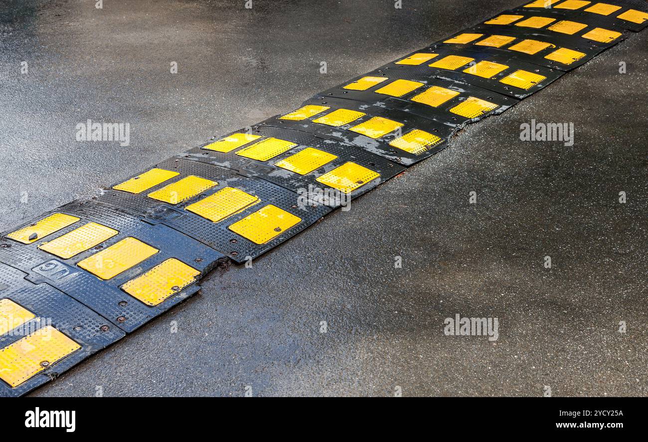 Traffic safety speed bump on an asphalt road Stock Photo - Alamy
