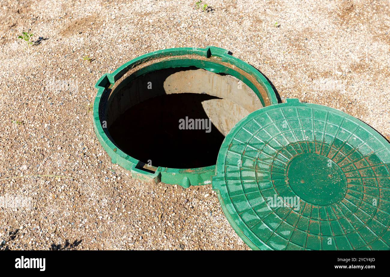 Opened unsecured sewer manhole of rural septic tank with green plastic ...