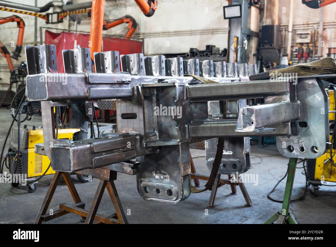 A large metal frame undergoing assembly in an industrial workshop ...