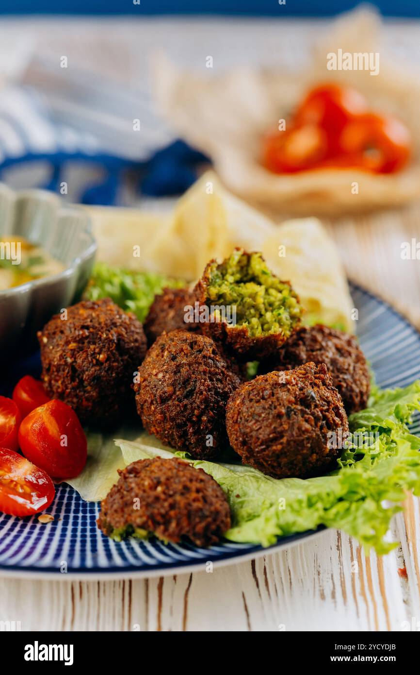 Falafel plate with hummus, cherry tomatoes, lettuce, and pita chips ...