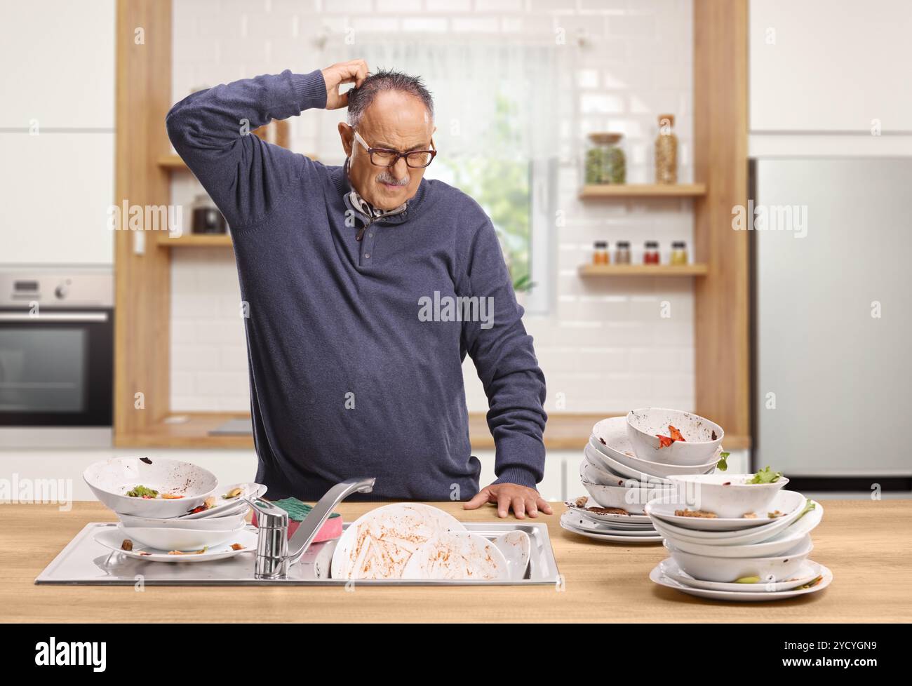 Confused mature man with a pile of dirty dishes in a kitchen sink Stock ...
