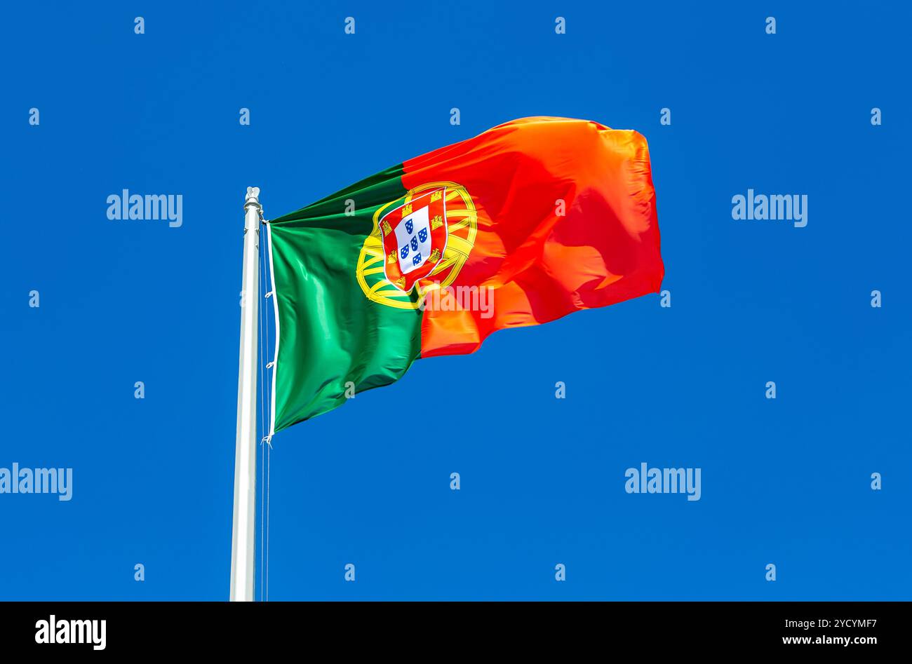 Portugal national flag against blue cloudy sky Stock Photo - Alamy