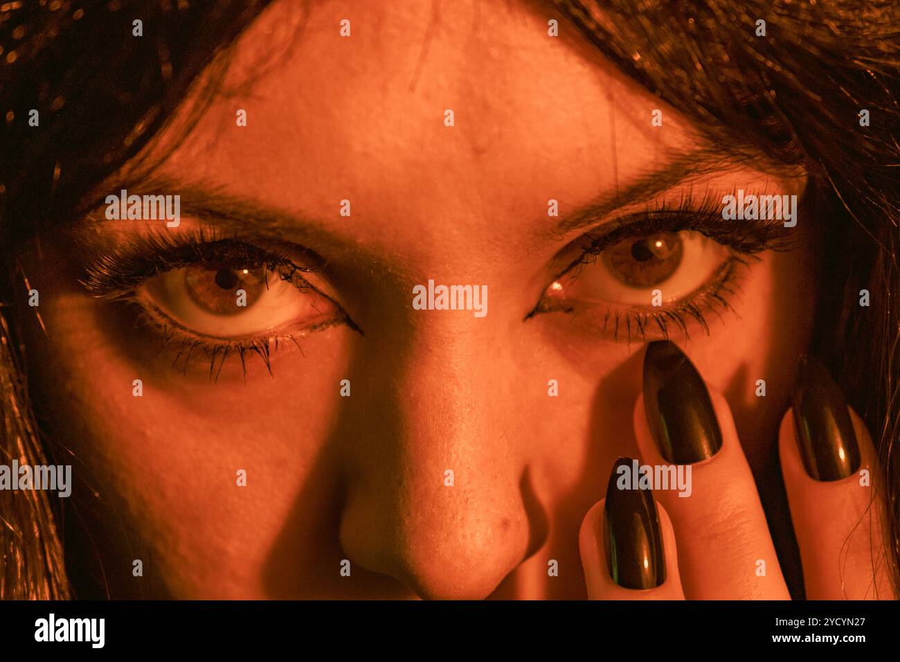 A close-up shot of a witch's face as she raises her long, sharp black ...