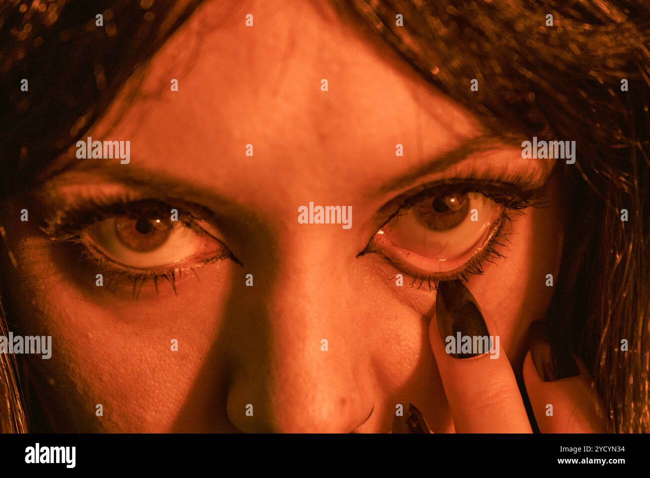 A close-up shot of a witch's face as she raises her long, sharp black ...