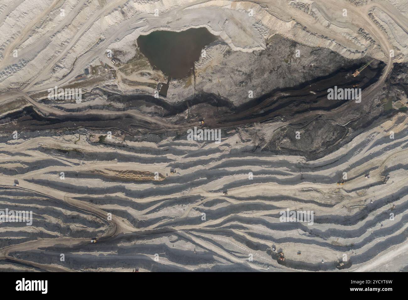 Coal seam in an open pit. Machinery working on coal mining Stock Photo ...