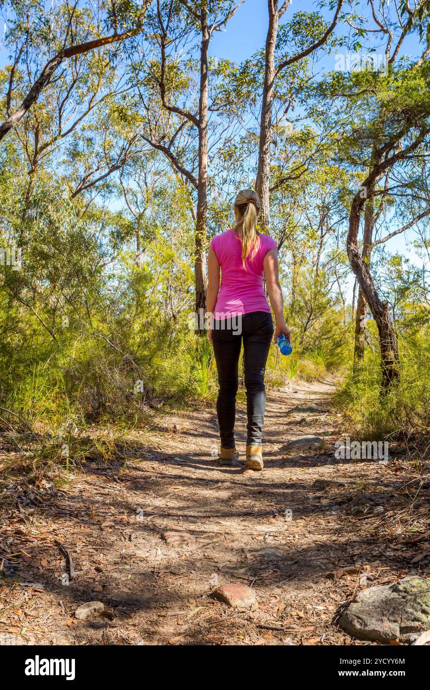 Female walking along a bush track among nature Stock Photo - Alamy