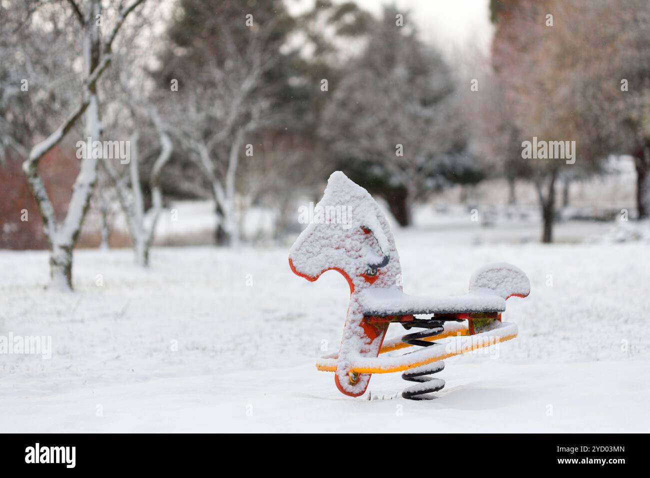 Playground equipment rocking horse covered in snow Stock Photo - Alamy