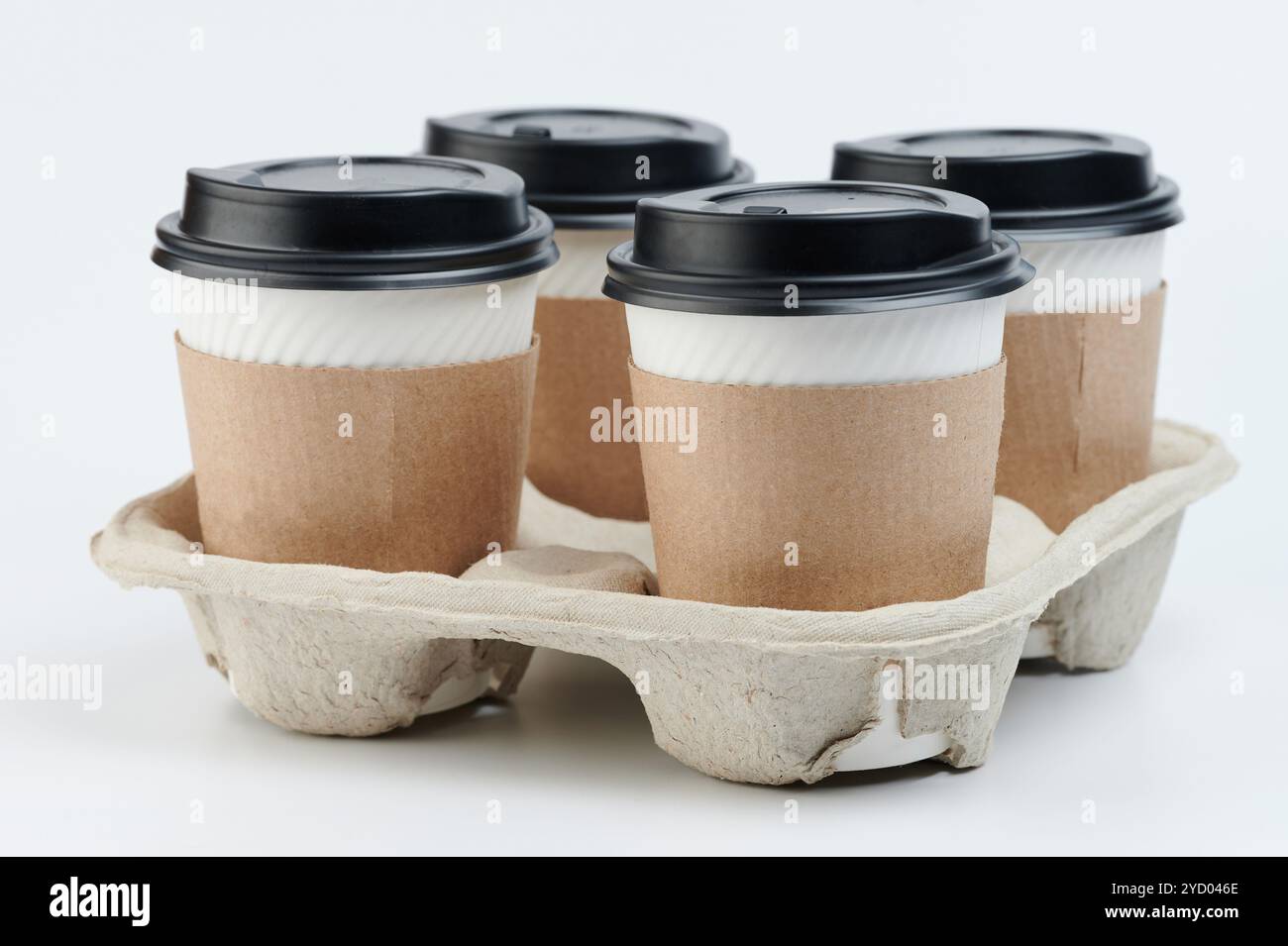 4 paper reusable cups in tray front view isolated on studio background ...
