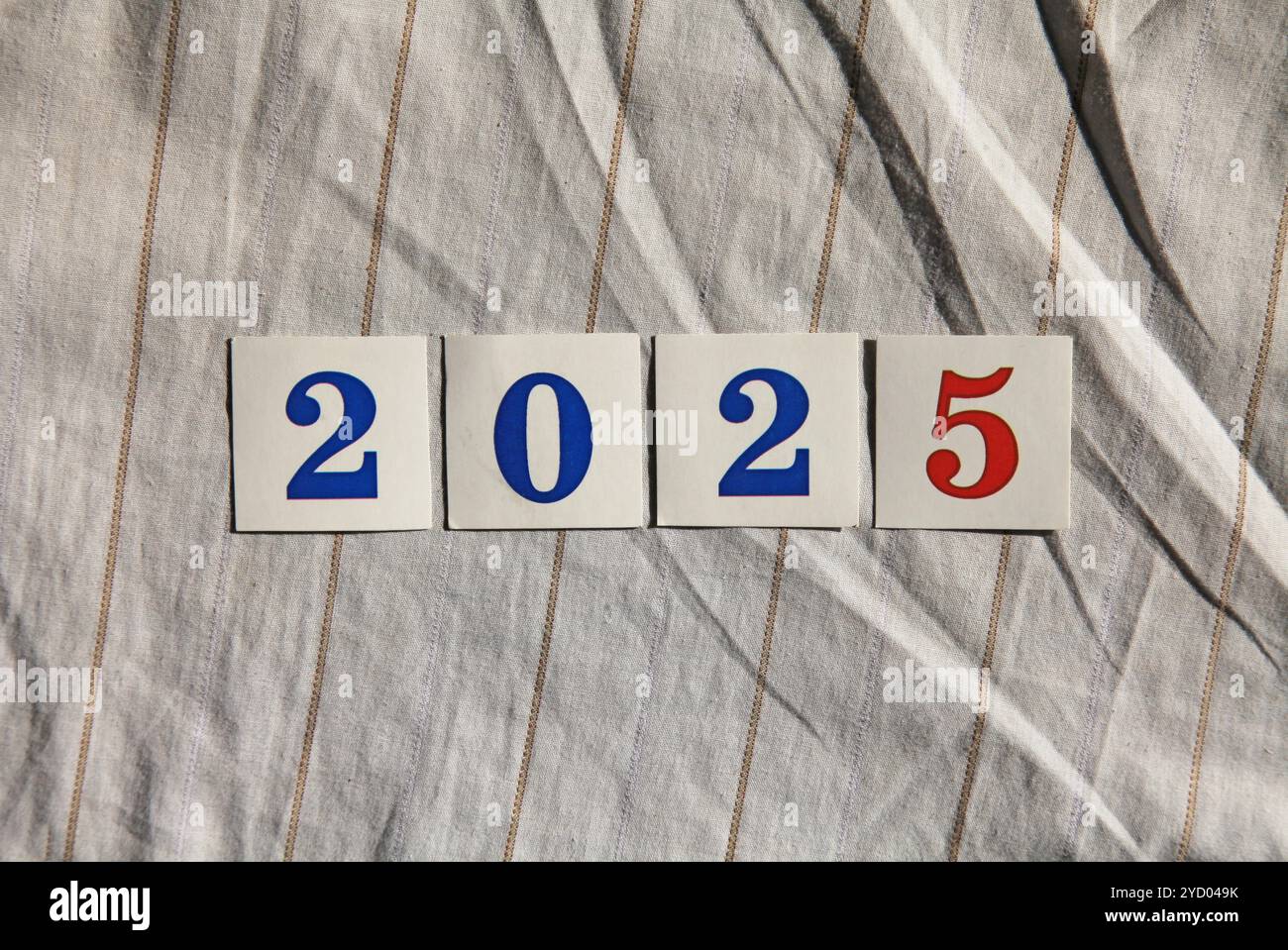 Numbers of 2025 year. Paper square numbers on the surface of wrinkled ...
