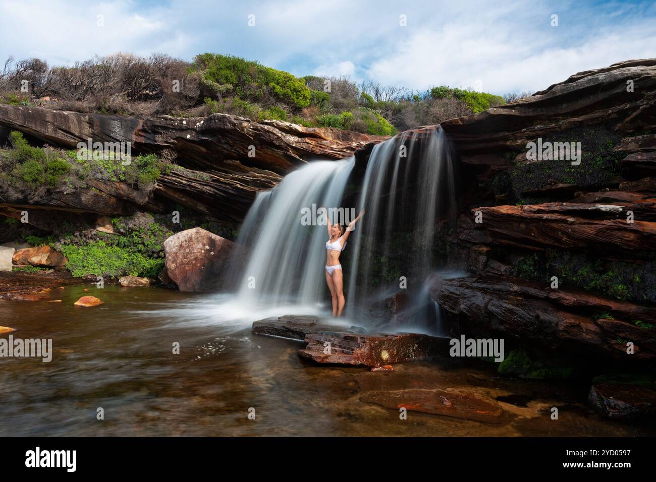 Happy woman standing under a waterfall in bushland wilderness Stock ...