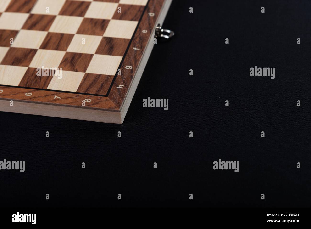 Part of an empty wooden checkers or chess board on a black background ...
