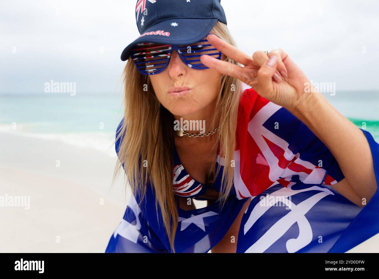 Proudly Australian woman lips pursed into a kiss and holding up two ...