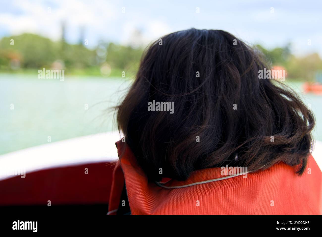Young adventurer ready to explore the lake, wind in her hair, safety ...