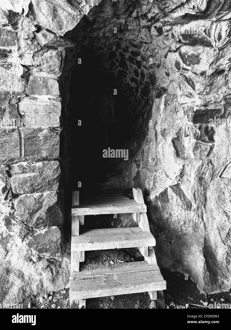 A mysterious cave entrance with worn wooden steps leading into darkness ... A mysterious cave entrance with worn wooden steps leading into darkness ...