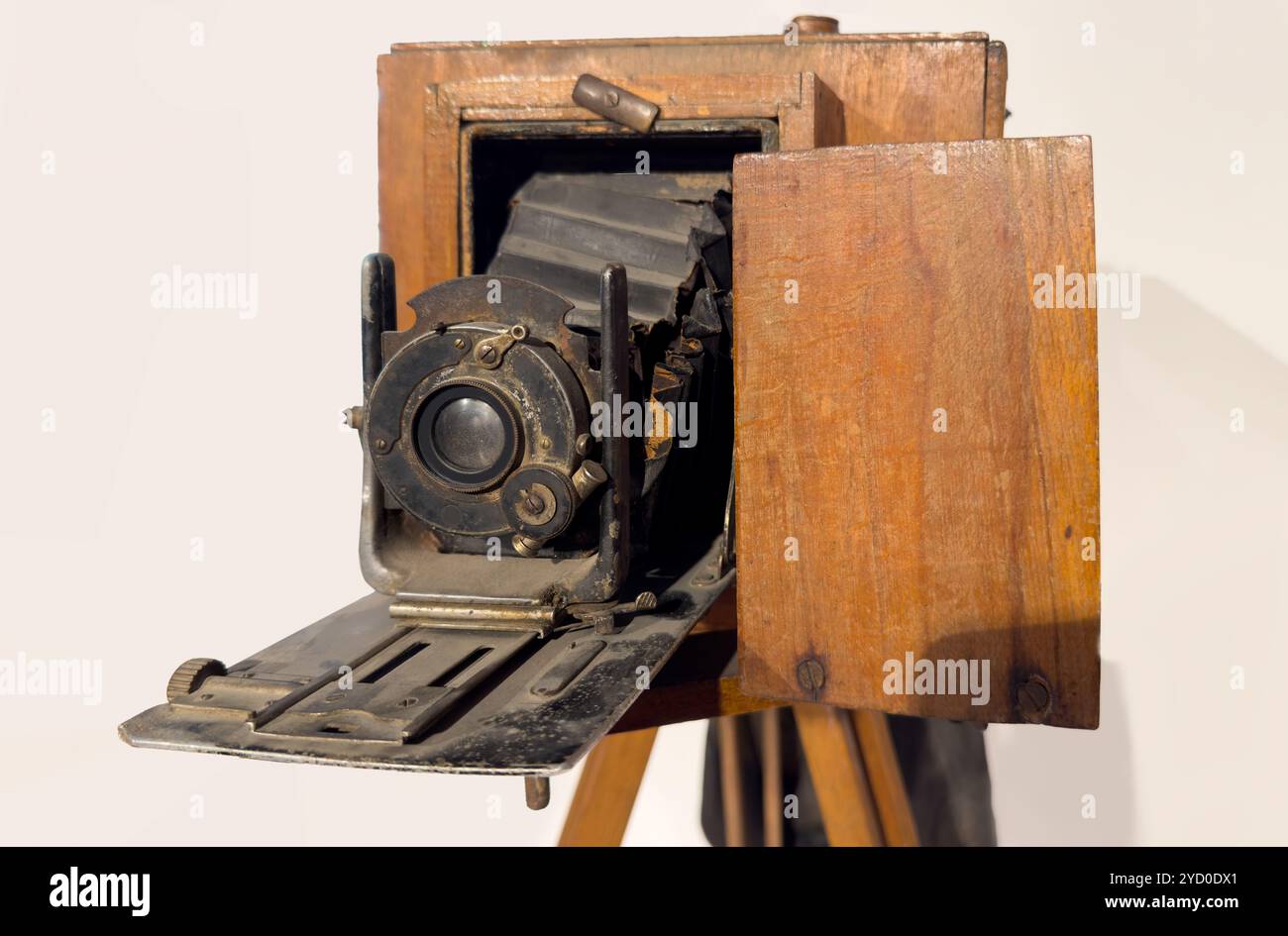 Diagonal view of an antique bellows camera in wooden case in white ...