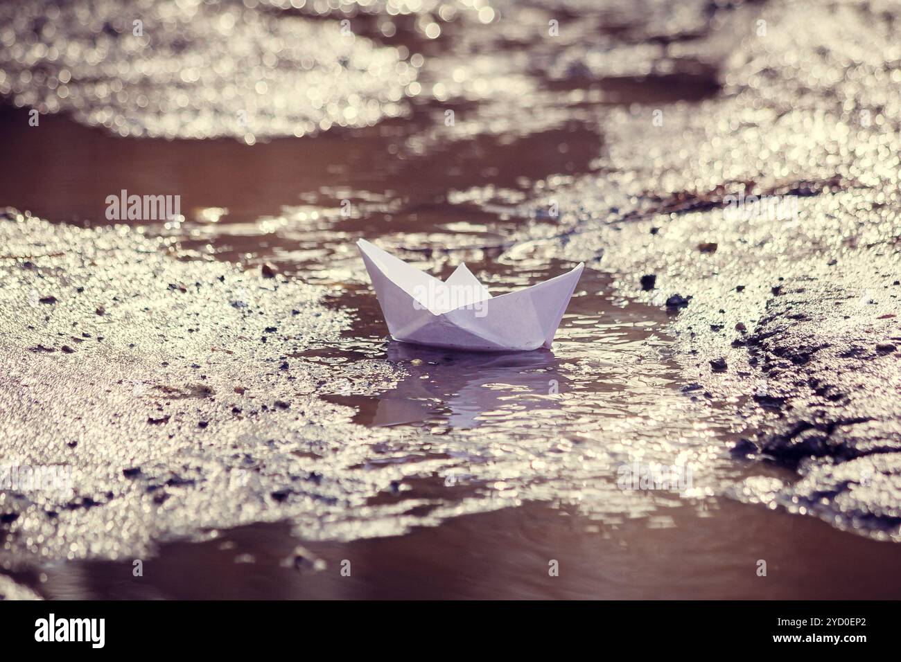 The paper boat floats through the spring puddles. Children's ...