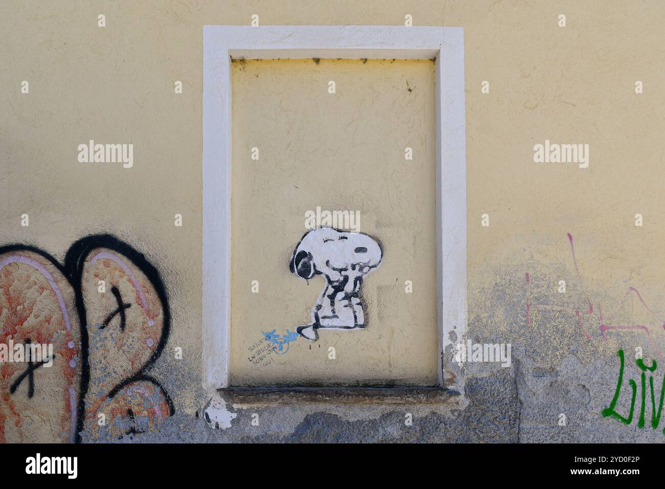 Snoopy comic character laughing on a flaked wall in the centre of Aosta ...