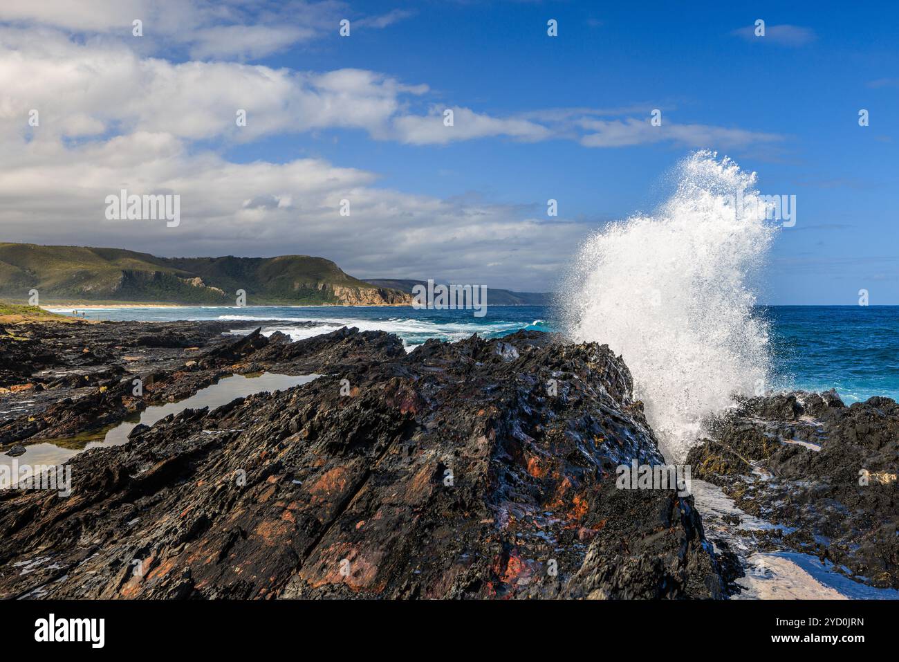 indian ocean waves crash spray into the air and into rock pools on the ...