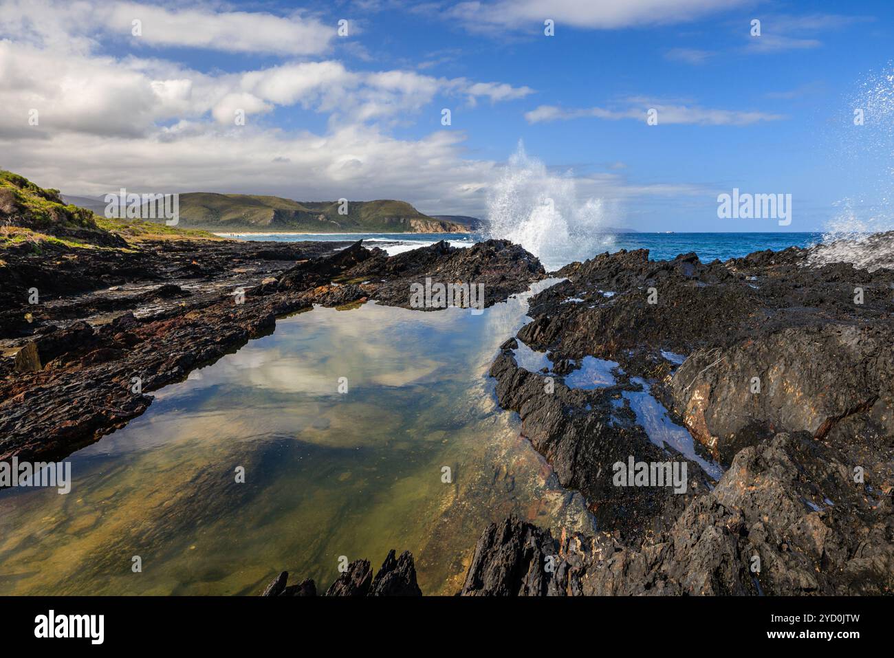 indian ocean waves crash spray into the air and into rock pools on the ...