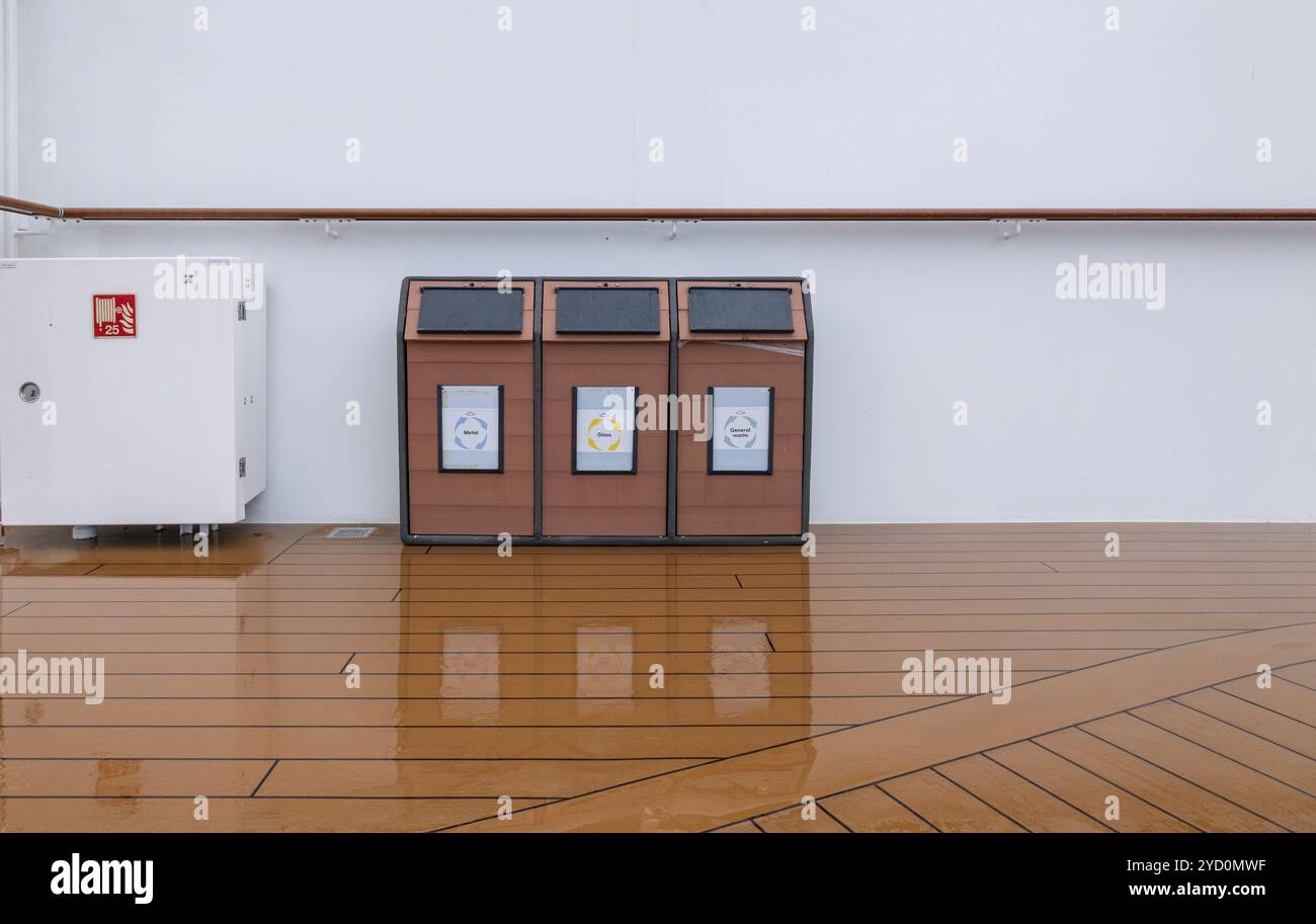 Containers with different types of garbage near color wall. Recycling ...