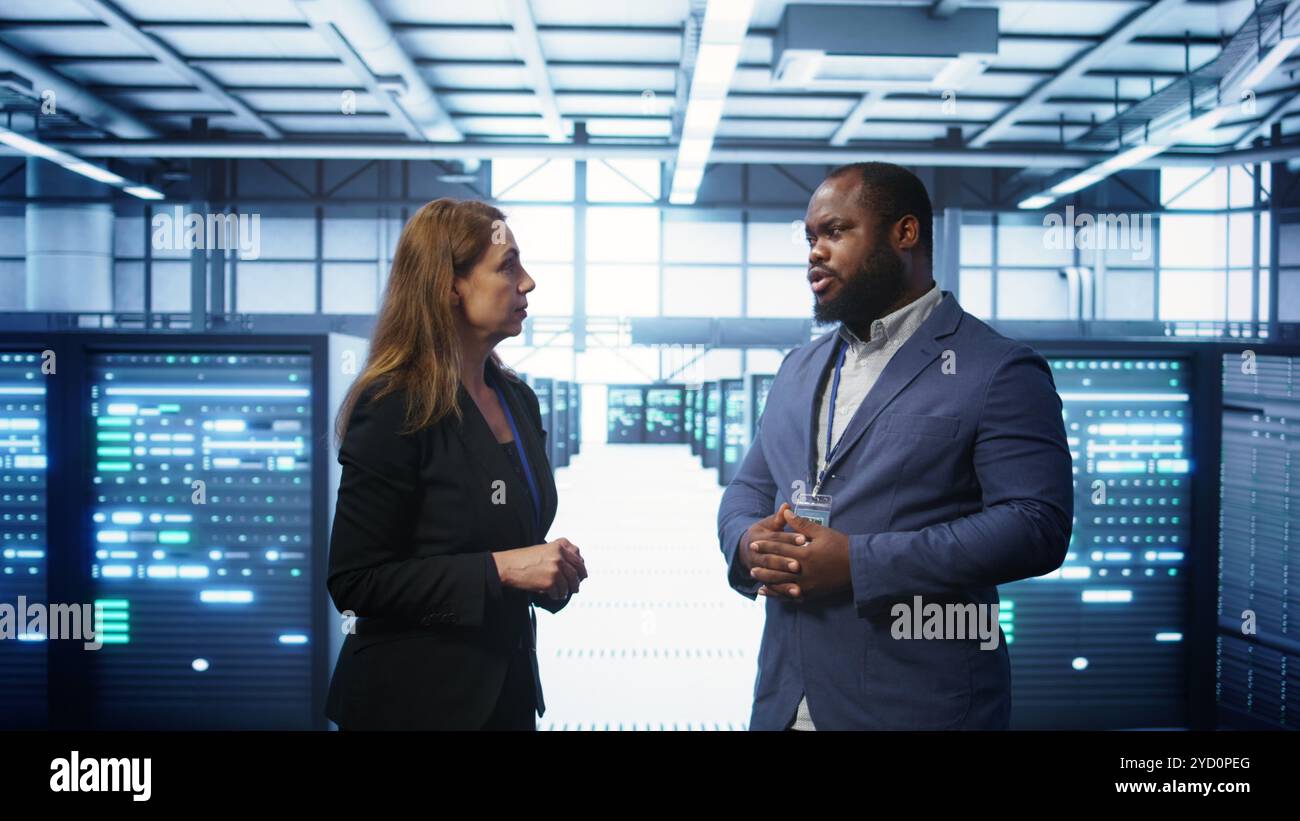 African american expert and coworker looking at holograms in data ...