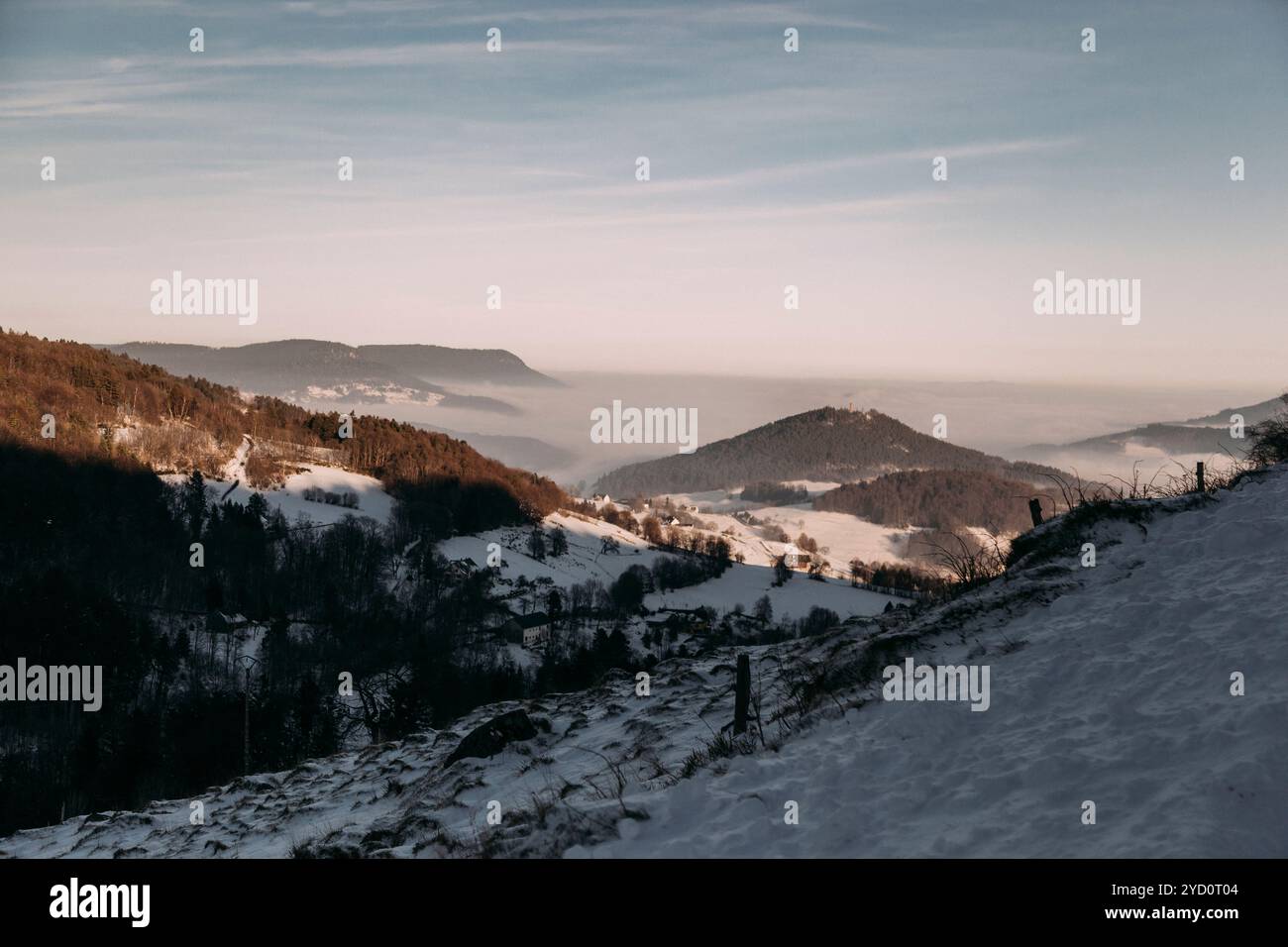 A serene winter vista features snow-covered hills and rolling mountains ...