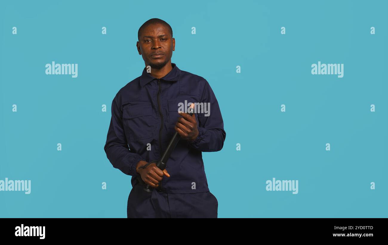 Portrait of security guard menacingly smacking hand with baton while ...