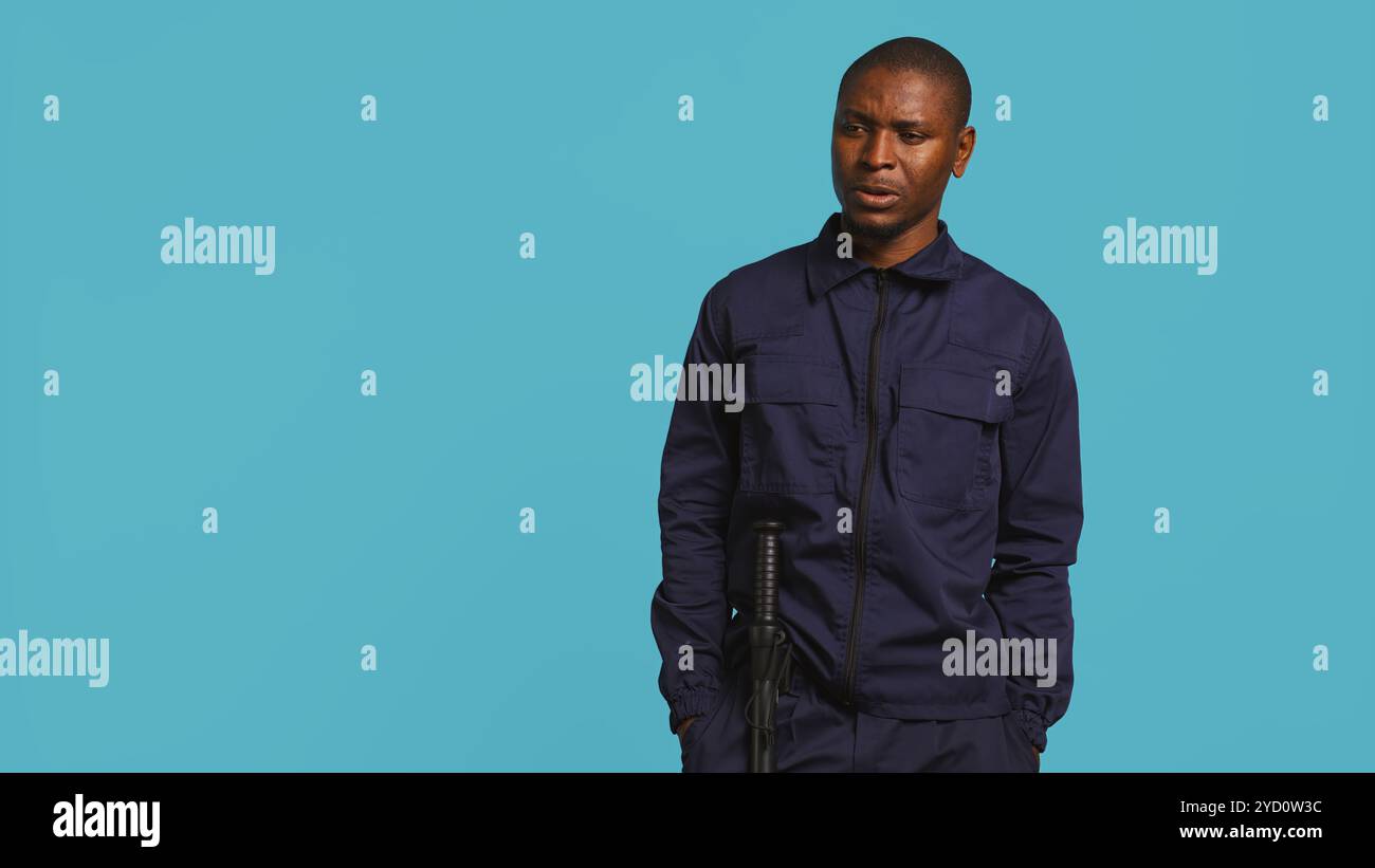 Portrait of security guard looking around while overseeing premises ...