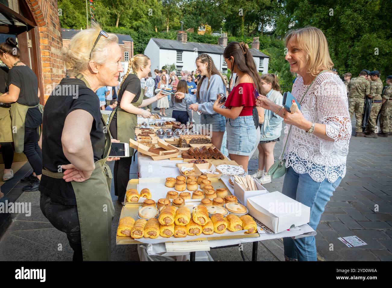 Lymm Food Festival 2024 -Women talk across a street bakery stall Stock ...