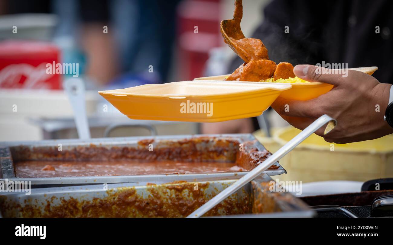 Lymm Food Festival 2024 - Indian food is ladled into a polystyrene tray ...