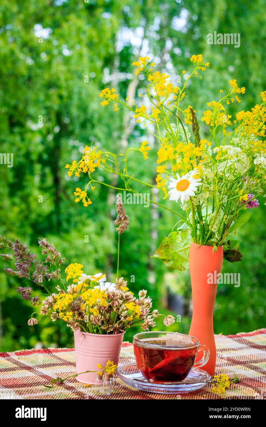 Summer tea with a book on the terrace. Summer tea with a bouquet of ...