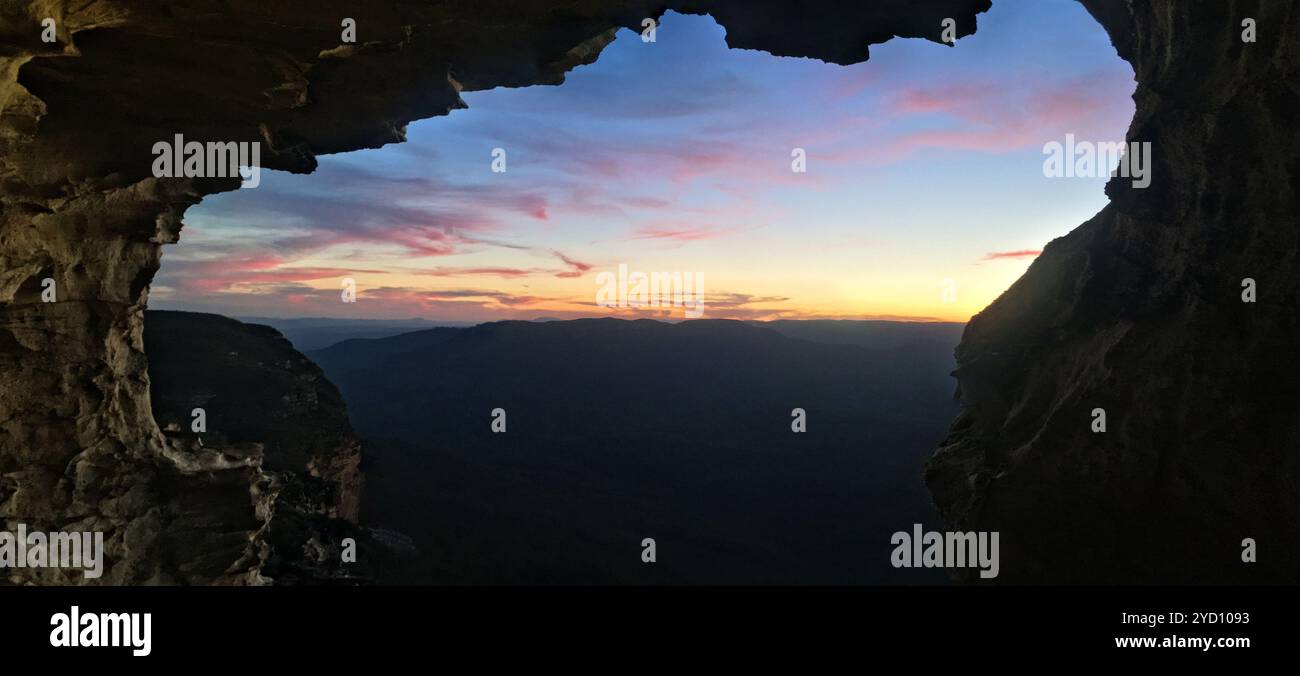 Mountain views to sunset from inside cliff cave Stock Photo - Alamy