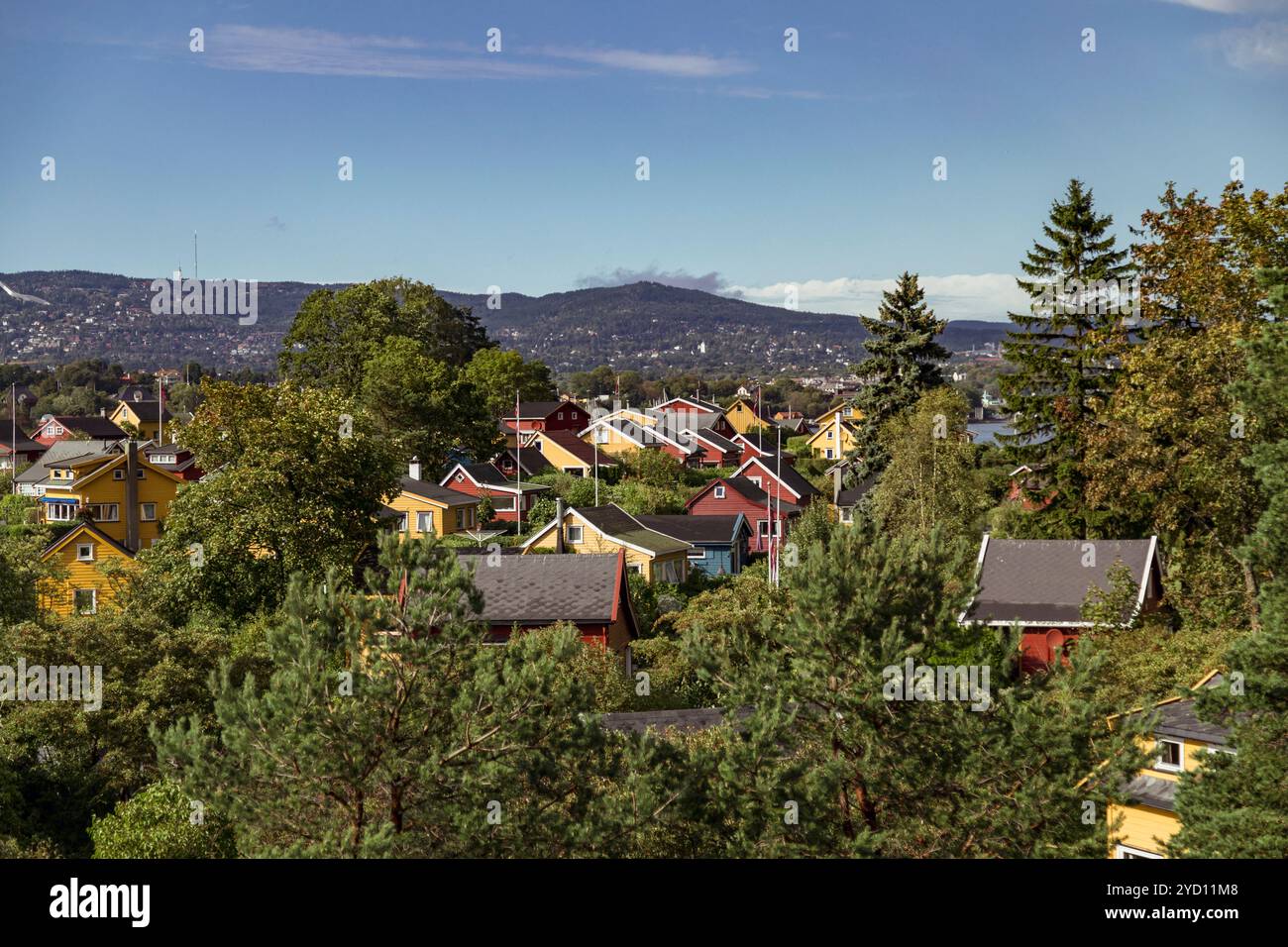 The view captures the charming houses of Oslo, surrounded by lush ...