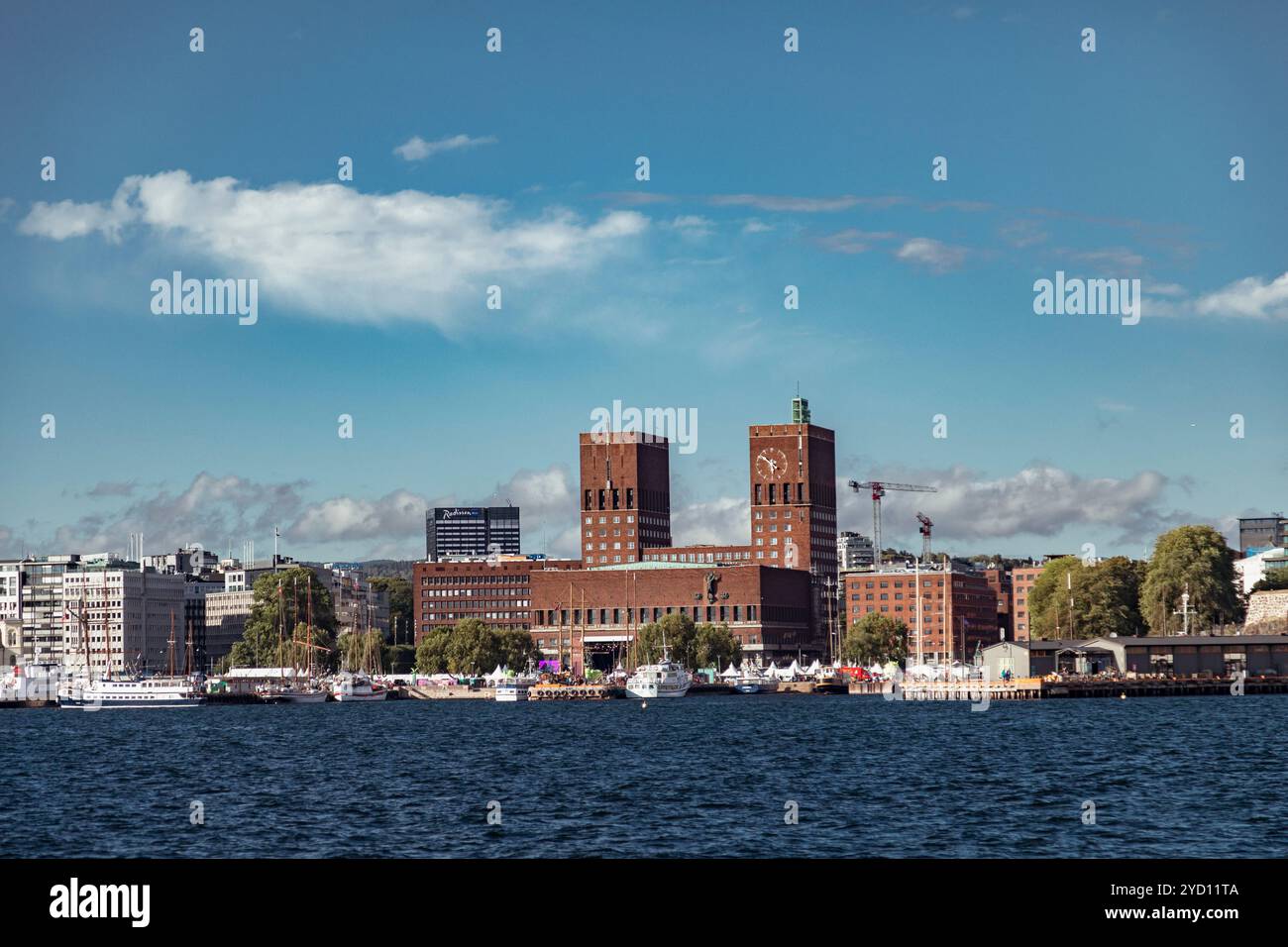 The iconic towers of Oslo City Hall dominate the skyline as boats ...