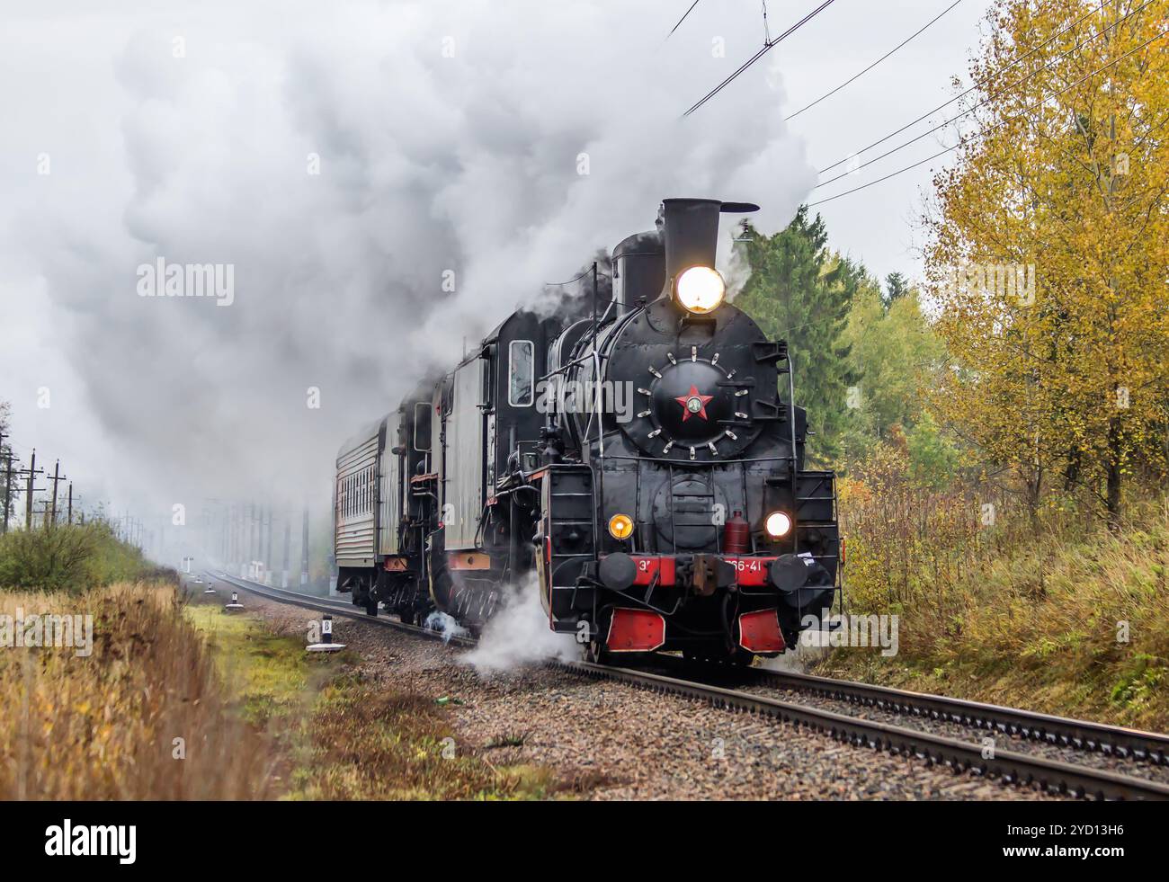 Old Russian locomotive on the railway. Old black locomotive. Smoke from ...
