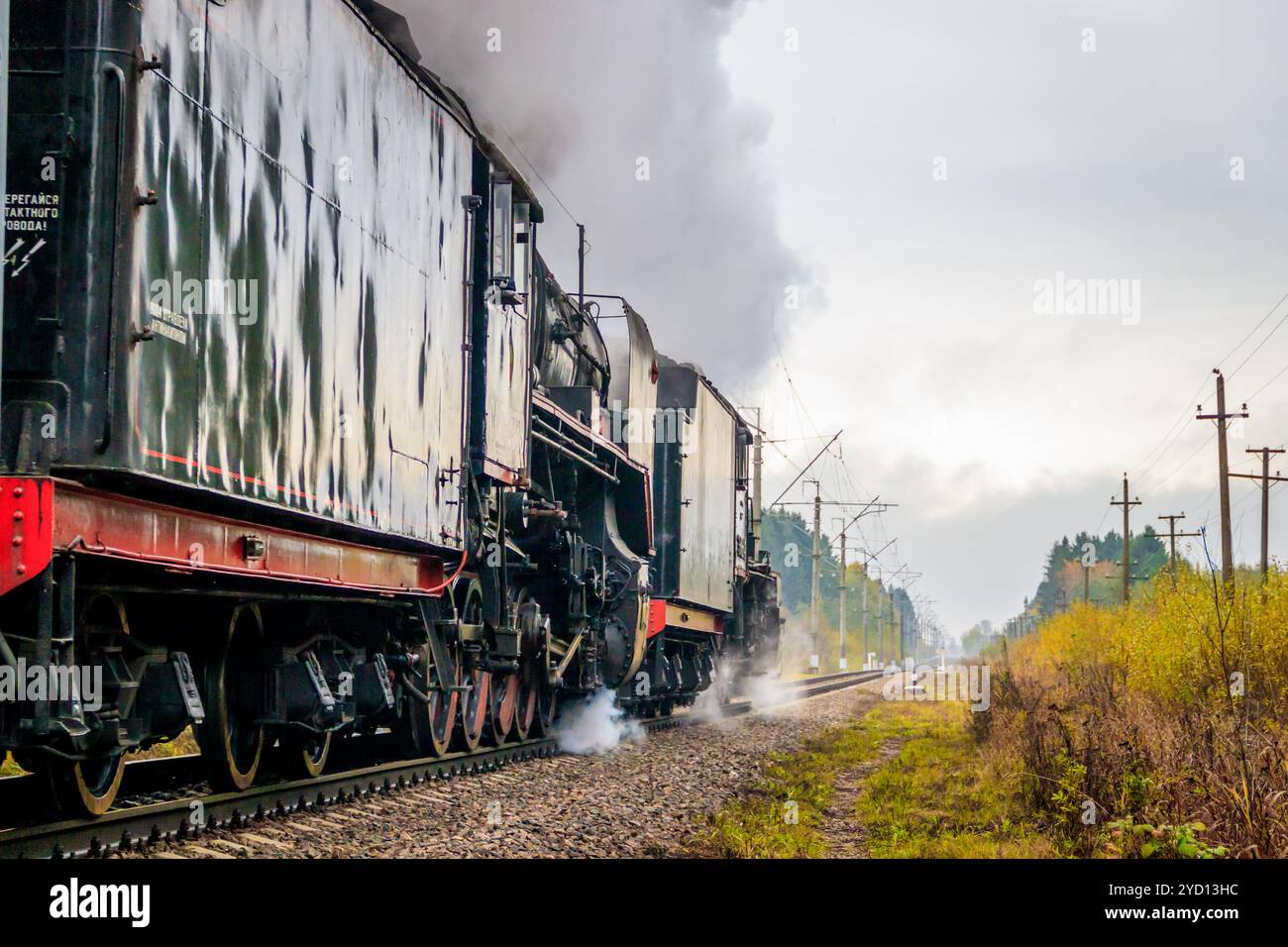 Old Russian locomotive on the railway. Old black locomotive. Smoke from ...