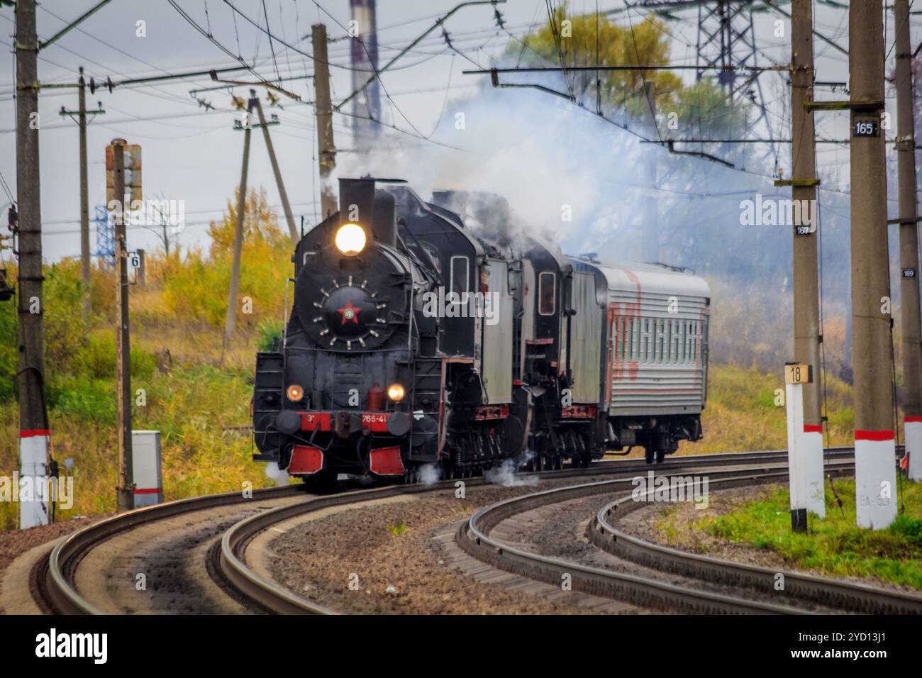 Old Russian locomotive on the railway. Old black locomotive. Smoke from ...