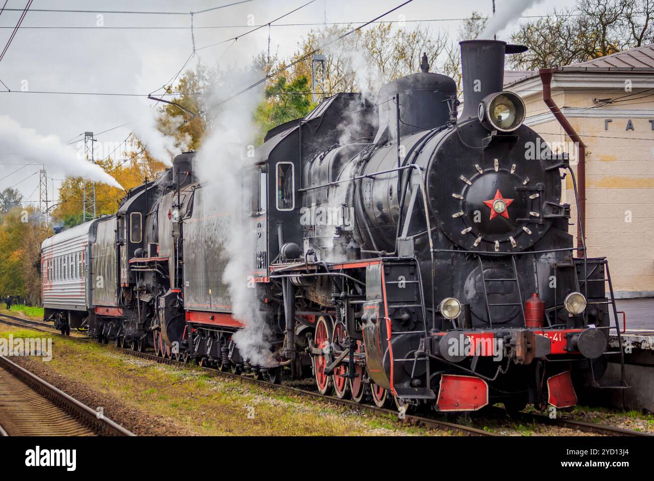 Old Russian locomotive on the railway. Old black locomotive. Smoke from ...