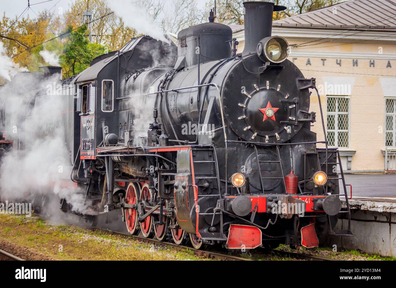 Old Russian locomotive on the railway. Old black locomotive. Smoke from ...