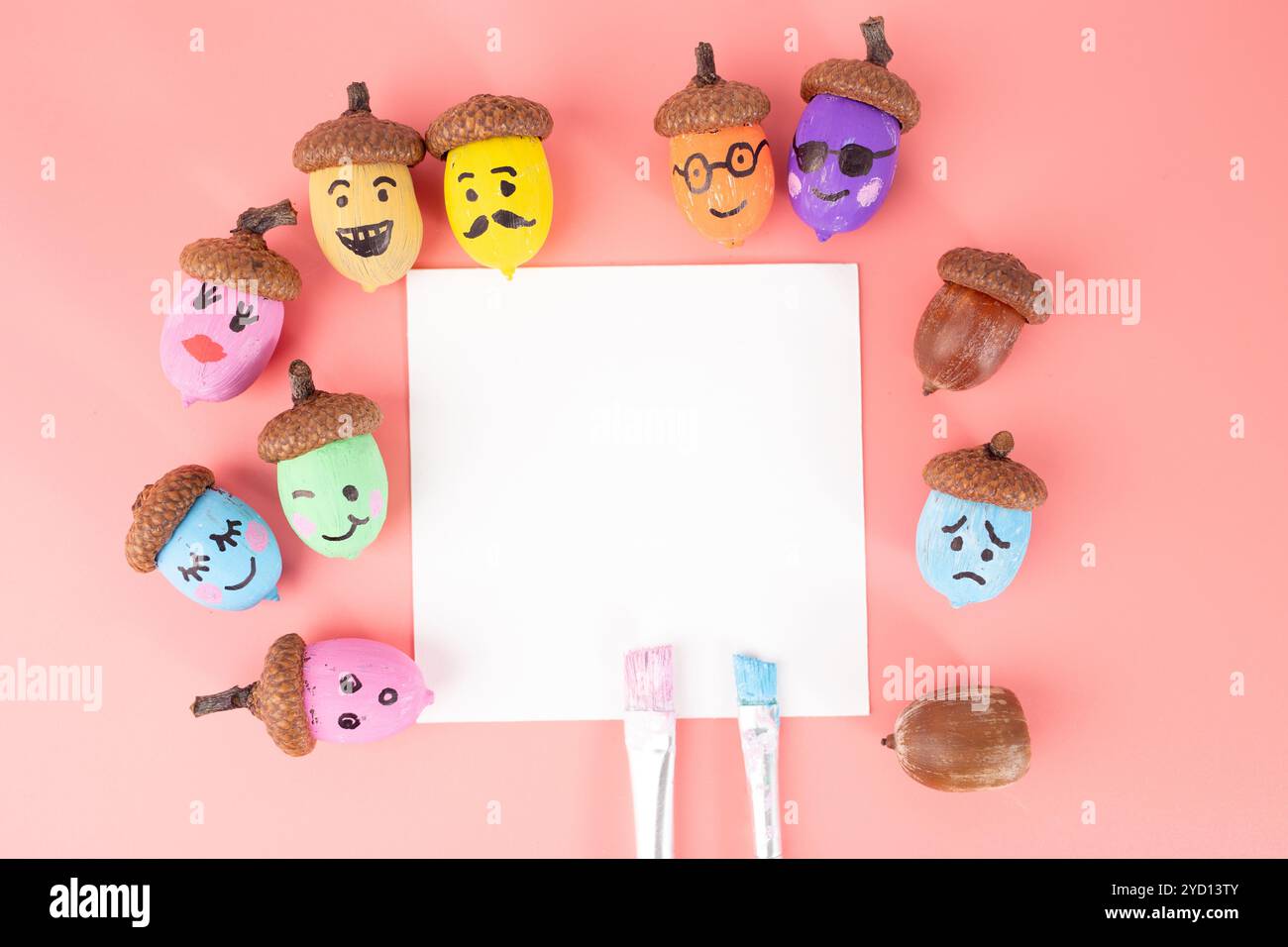 Colorful acorns with facial expressions around blank white square, pink ...