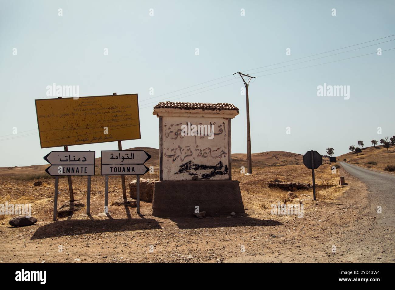 A rural area in Morocco features a weathered signpost indicating ...