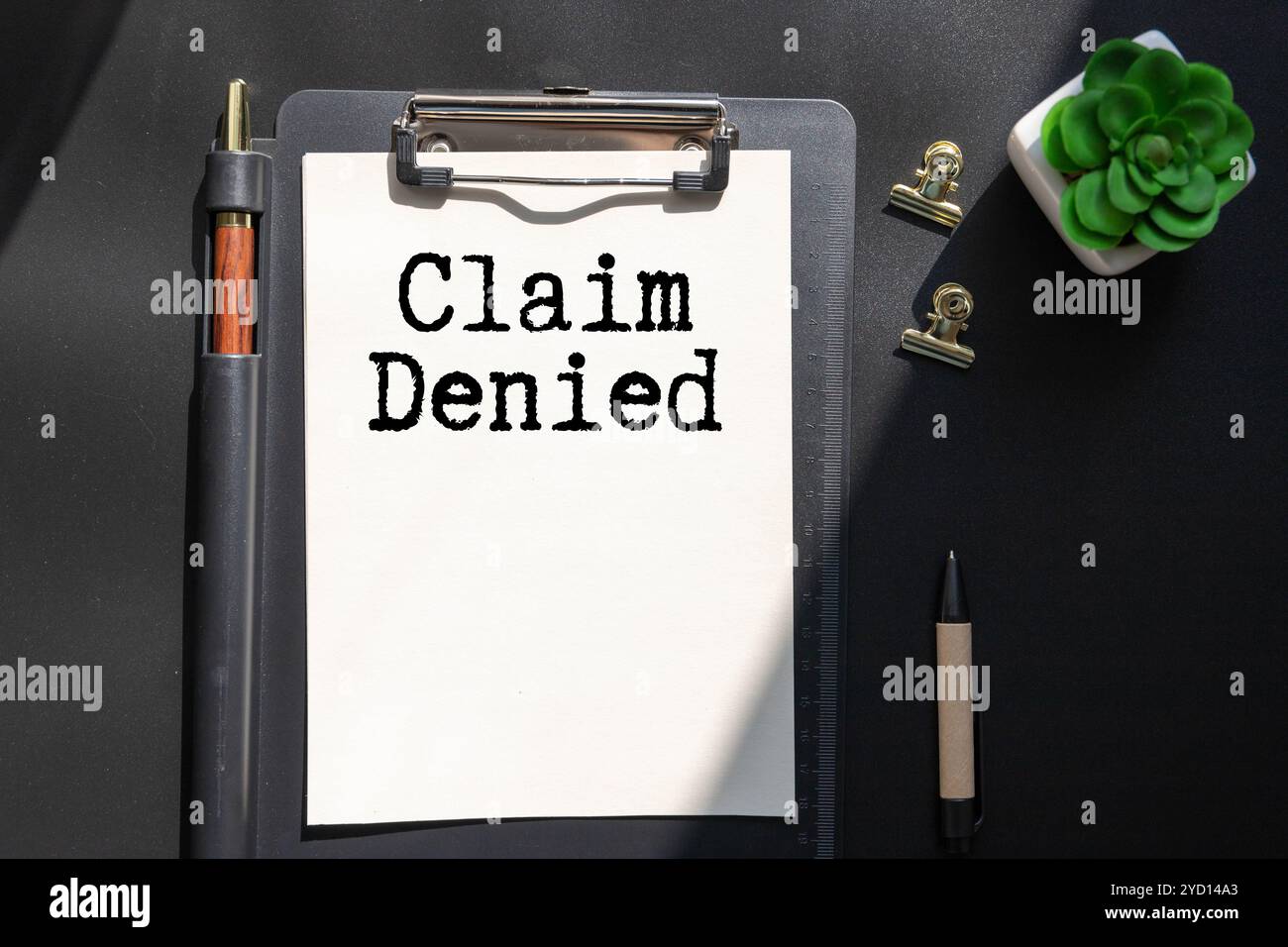 Pink card with the text CLAIM DENIED on wooden background. Flat layout ...