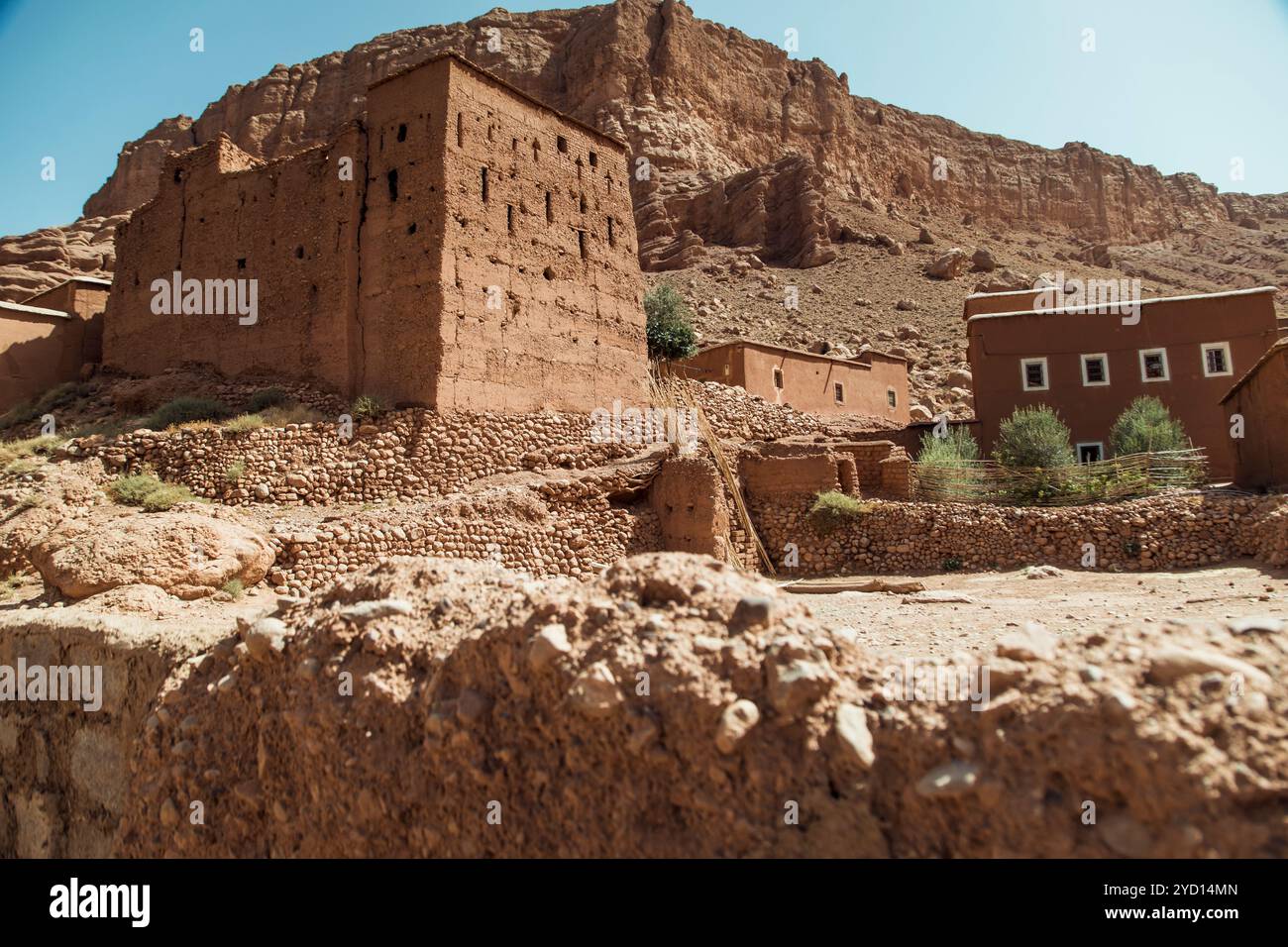 Historic adobe buildings rise from the dry, rocky terrain of Morocco’s ...