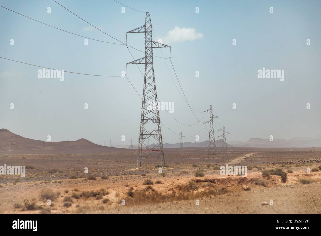 In the vast arid landscape of Morocco, towering electrical transmission ...