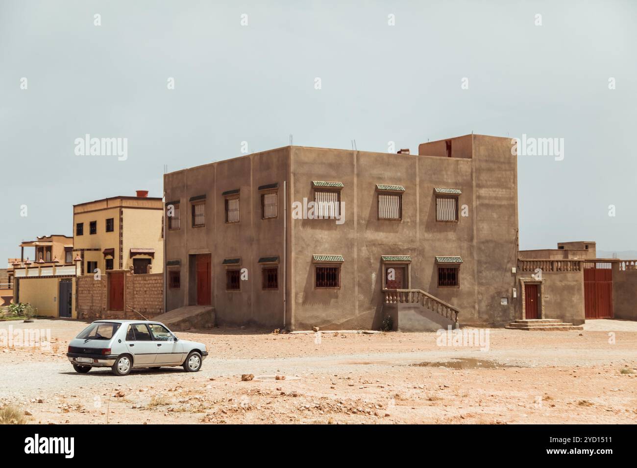 A mid-size family car is parked in front of a distinctive residential ...